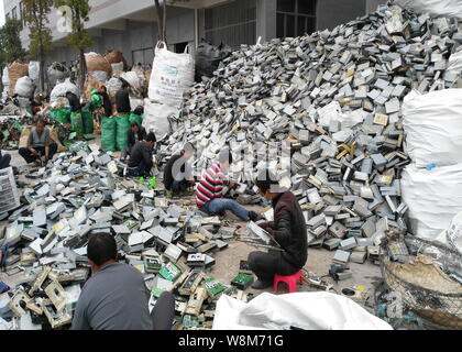 Chinese workers remove components from hard drives of computers at a ...