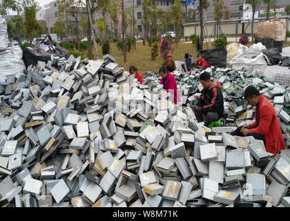 Chinese workers remove components from hard drives of computers at a ...
