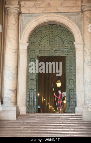 A Pontifical Swiss guard armed with a halberd standing outside St Peter ...