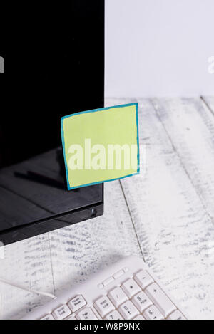 Notation paper taped to black computer monitor screen near white ...