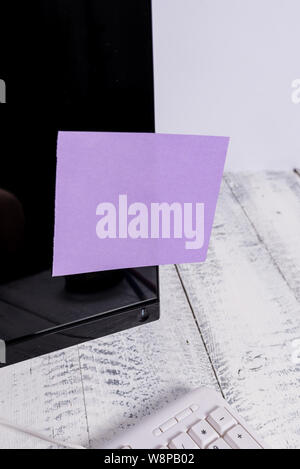 Notation paper taped to black computer monitor screen near white ...