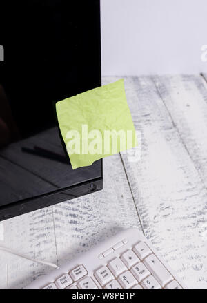 Notation paper taped to black computer monitor screen near white ...