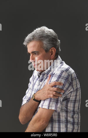 Indian senior man with arm pain standing outdoor at park. Asian Old man ...