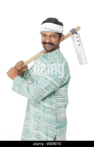 Indian farmer carrying hoe on his shoulder standing in field Stock ...