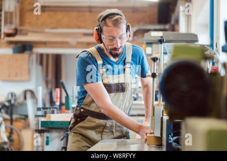 Absorbed carpenter at the milling machine working on wood Stock Photo ...