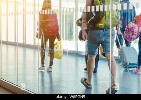 Glass boarding corridor from airport terminal, airplanes in background ...