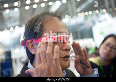 A visitor tries out a smart glasses at the China International Supply ...