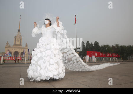 Chinese artist Kong Ning dressed in a 10-meter-long wedding gown made ...