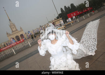 Chinese artist Kong Ning dressed in a 10-meter-long wedding gown made ...