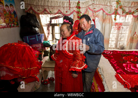 47-year-old Chinese villager Xiang Junfeng, dressed in a white wedding ...