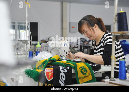 A female Chinese worker sews a fan scarf produced for the 2014 Brazil ...