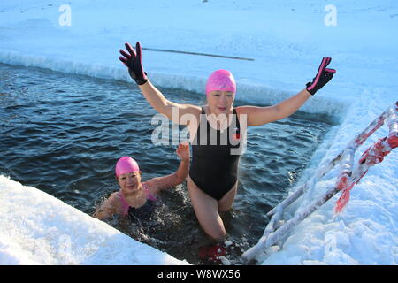 Winter swimming enthusiasts swim in an icy swimming pool during a ...