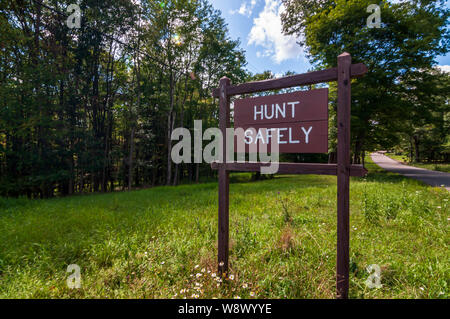 A wooden sign saying HUNT SAFELY on the side of a road in Warren county ...