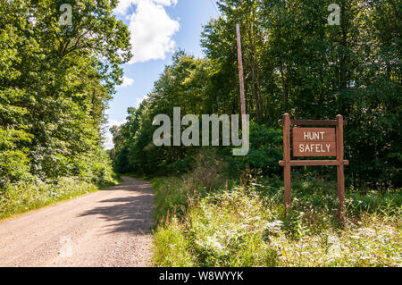 A wooden sign saying HUNT SAFELY on the side of a road in Warren county ...