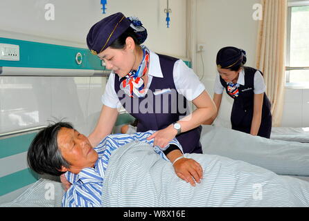 A Chinese nurse dressed like a flight attendant examines a patient at ...