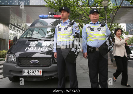 Chinese police officers armed with shields patrol on Huaihai Road in ...