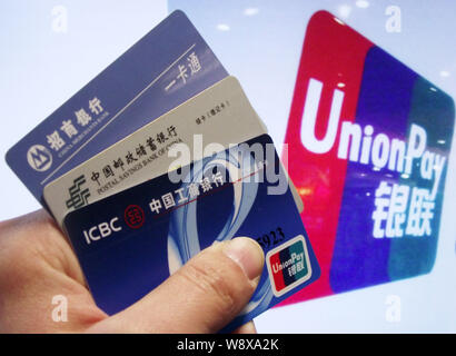 --FILE--A local resident shows a debit card of Postal Savings Bank of ...