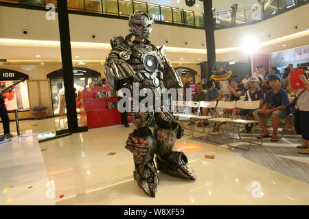 A performer dressed in his Transformers costume poses during a ...