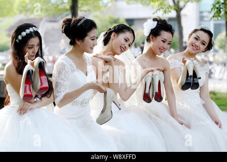--FILE--Female Chinese graduates dressed in wedding gowns pose for ...