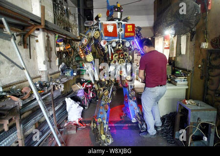 Liu Bo, a Chinese repairman, adjusts a Transformer robot made from ...