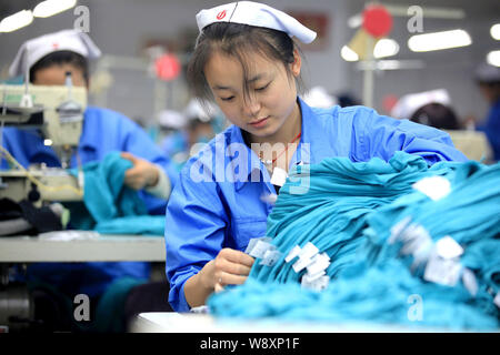 --FILE--Chinese workers make shirts at the garment factory of Qingdao ...