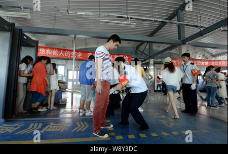 A guard scans a passenger for security check at a subway station in ...