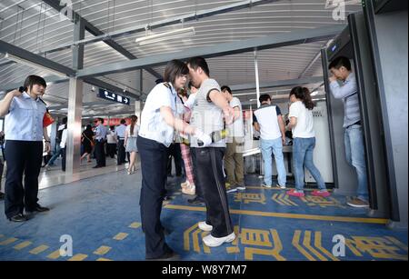 A guard scans a passenger for security check at a subway station in ...