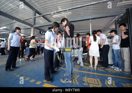 A guard scans a passenger for security check at a subway station in ...