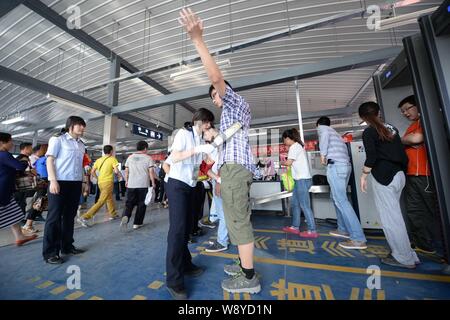 A guard scans a passenger for security check at a subway station in ...