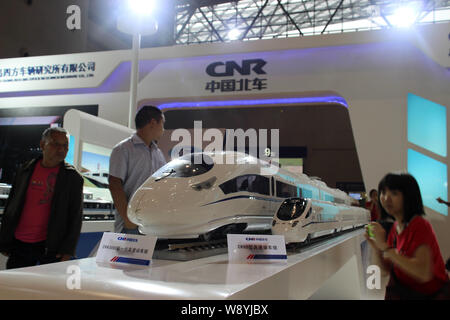 --FILE--Visitors look at models of CRH trains at the stand of CNR ...