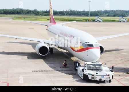 --FILE--A ground crew member looks at a Boeing 747-400 jet plane of Air ...