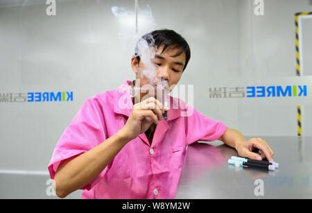 --FILE--A Chinese employee tests electronic cigarettes in a lab at the ...