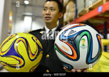 A Chinese customs officer shows a seized fake World Cup trophy at a ...
