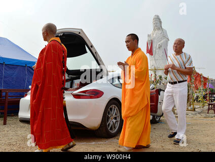 Chinese Buddhist monks bless a Porsche sports car during a great dharma ...