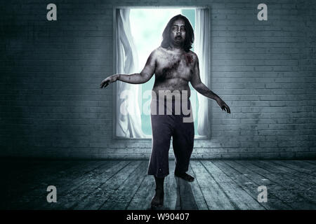 Scary zombies with blood and wound on his body walking in the haunted ...