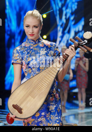 A foreign model displays a creation of cheongsam, also known as qipao ...