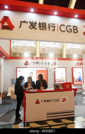 --FILE--A visitor talks with employees at the stand of China Guangfa ...