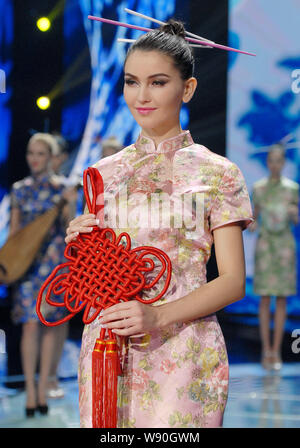 A foreign model displays a creation of cheongsam, also known as qipao ...