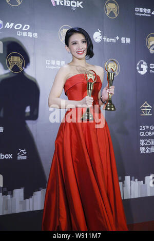 Malaysian singer Penny Tai holds up her trophies for Best Mandarin ...