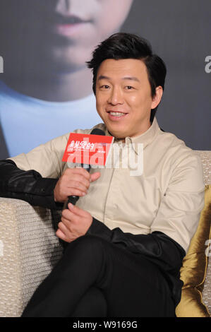 Chinese actor Huang Bo speaks holding a bouquet of flowers at a ...