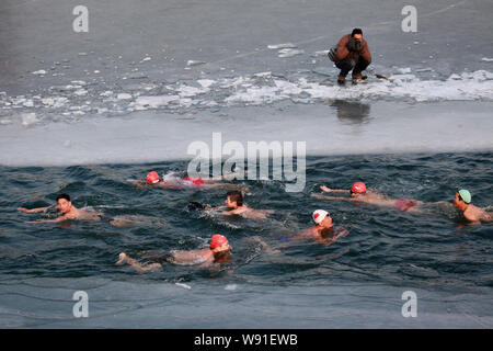 Winter swimming enthusiasts swim in an icy swimming pool during a ...