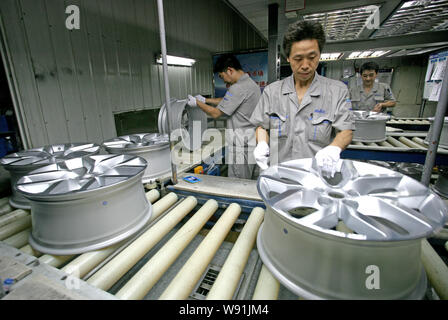 --FILE--Chinese workers examine car rims on the production line at a ...