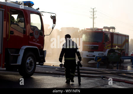 Chinese firemen try to extinguish a fire in an LPG tank storage station ...