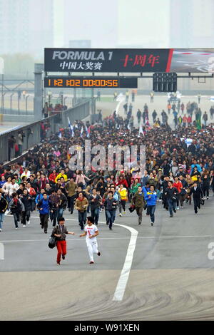 A crowd of Formula One fans run on the track during a celebration for ...