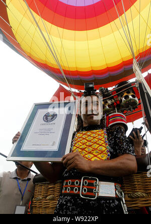 Chinese Uighur tightrope walker Aisikaier Wubulikaisimu holds up his ...
