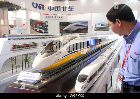 A visitor looks at models of CRH trains at the stand of CNR £¨China ...