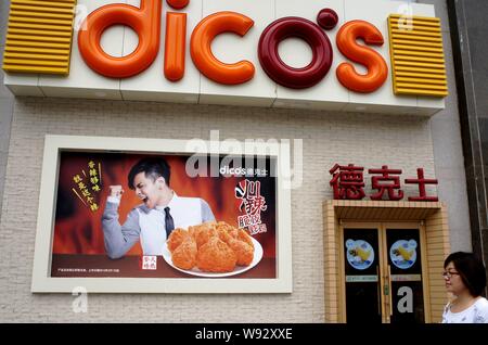 A pedestrian walks past a Dicos fastfood restaurant in Chongqing, China ...