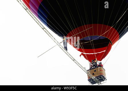 Chinese Uighur tightrope walker Aisikaier Wubulikaisimu holds up his ...