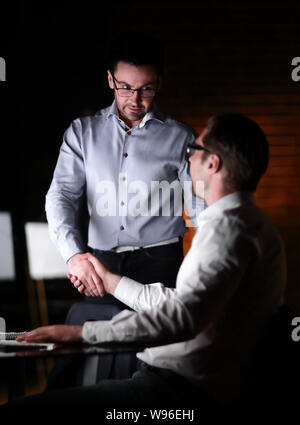 employees shaking hands near the desktop Stock Photo - Alamy