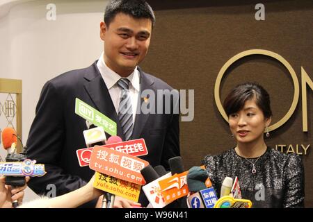 Retired Chinese basketball superstar Yao Ming, left, listens to Ye Li ...